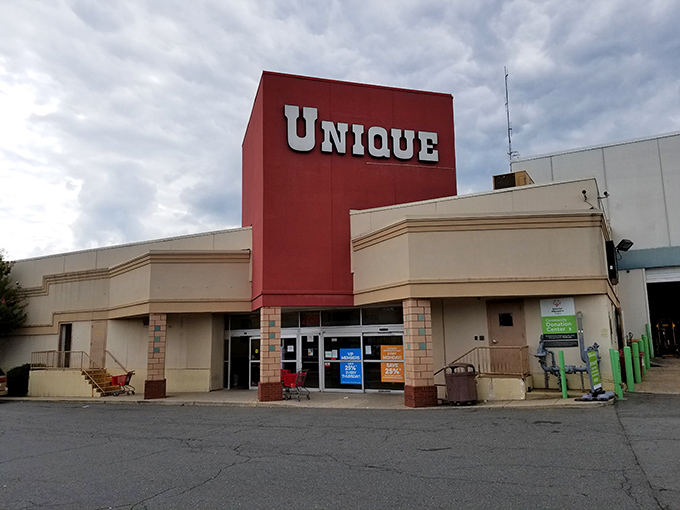 The iconic red "UNIQUE" sign beckons bargain hunters like a lighthouse for the thrift-obsessed. Adventure awaits inside!