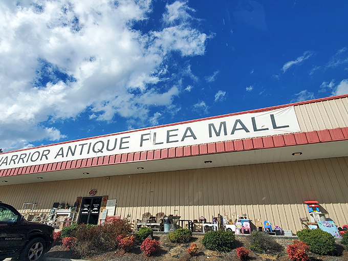 Warrior Antique Flea Mall's bright red trim stands out against the Alabama sky. A siren call to collectors and nostalgia-seekers alike.