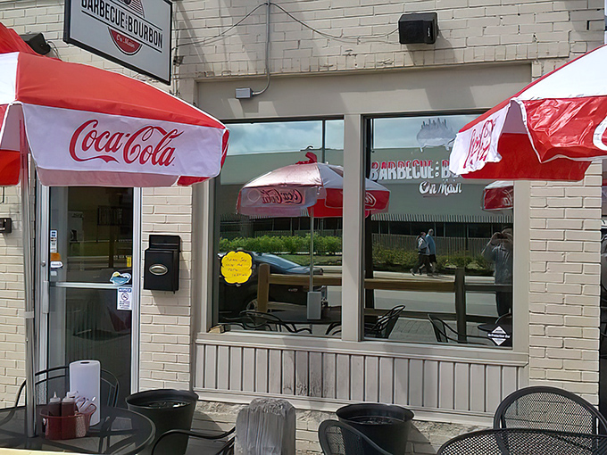 Coca-Cola umbrellas and outdoor seating - the universal signal for "slow down and enjoy life" at this BBQ spot.