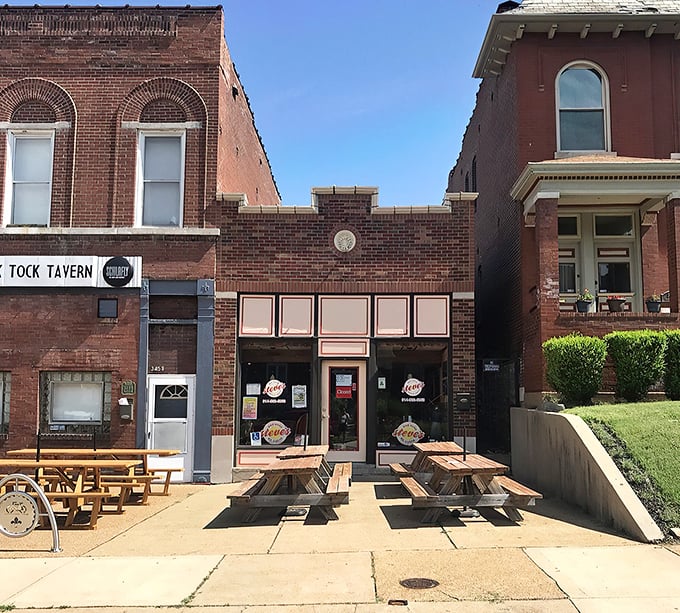 The Tick Tock Tavern's outdoor seating area: where St. Louis hot dog dreams come true under a canopy of crimson umbrellas.
