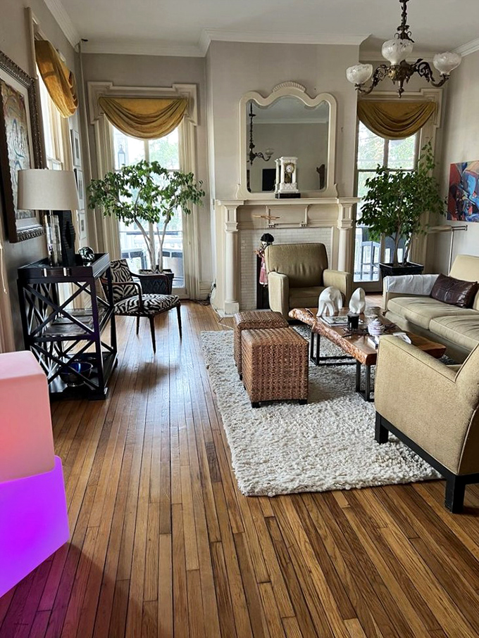 Sunlight streams through tall windows into this tastefully appointed living area, where modern comfort meets historical charm in perfect harmony.
