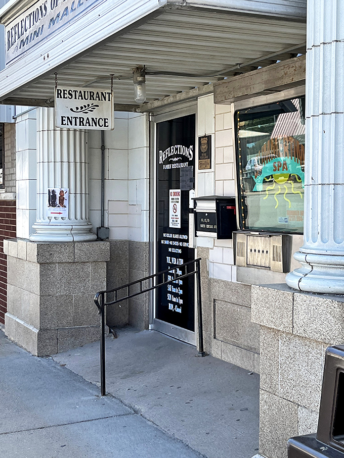 The historic Reflections Family Restaurant entrance promises hearty meals with a side of nostalgia. No molecular gastronomy here, just honest cooking worth the trip.