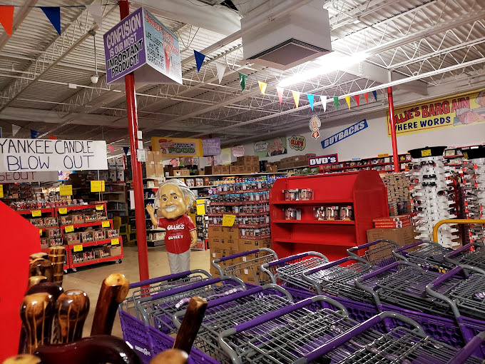 Shopping carts await their mission while the store mascot stands guard near a "Yankee Candle Blow Out" that would make any home fragrance enthusiast weak at the knees.