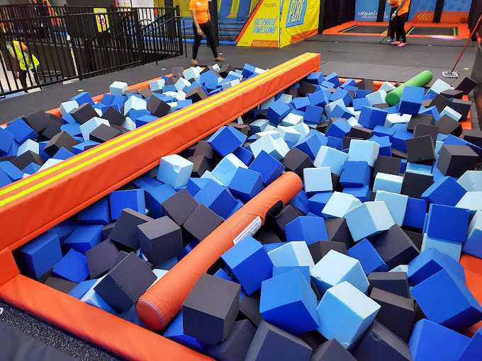 Suspended swings and colorful obstacles create a neon-lit playground that would make even the most serious adult reconsider their definition of fun. 