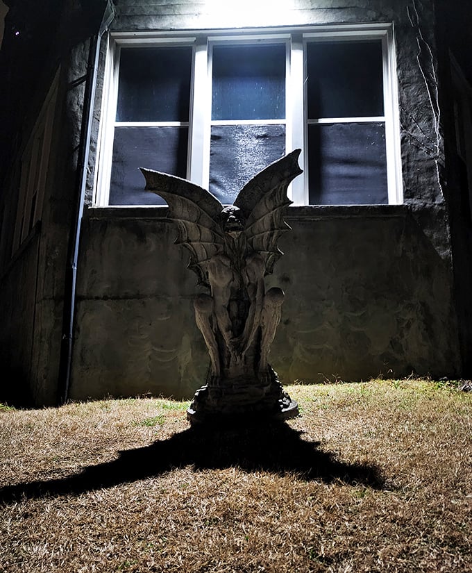 Nothing says "welcome to your nightmare" quite like a gargoyle statue casting an ominous shadow against the sanatorium's weathered walls.