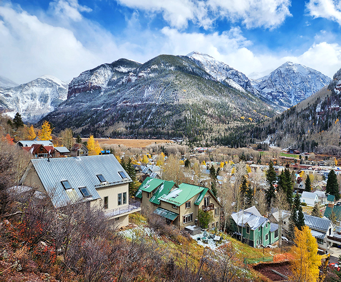 A patchwork of metal rooftops and aspen trees creates a mountain village mosaic. Telluride's residential area offers views that make mortgage payments seem reasonable.