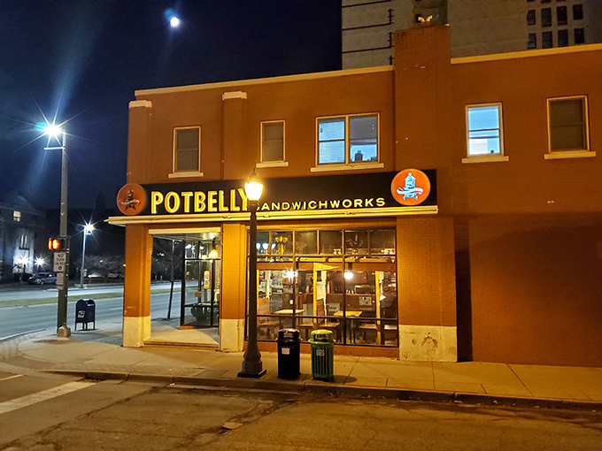 Potbelly's glowing storefront at night stands like a lighthouse, guiding hungry souls through the darkness toward sandwich salvation.