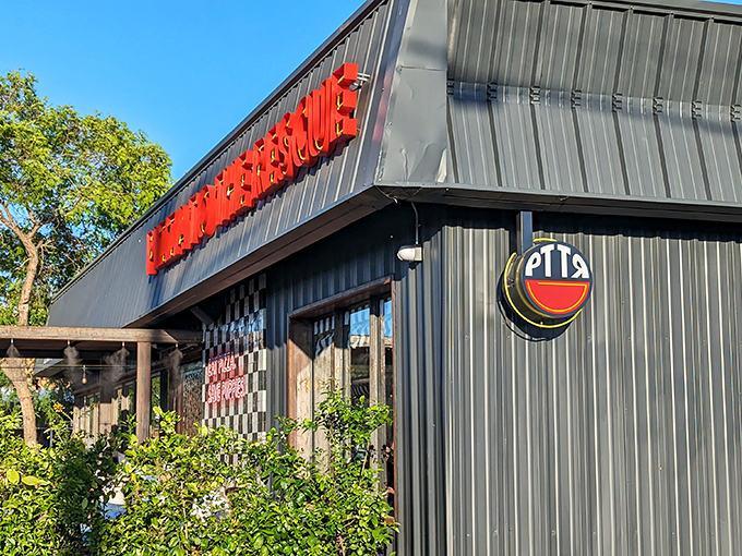The bold red lettering against industrial metal siding &ndash; like a superhero's lair for fighting hunger one pizza at a time.