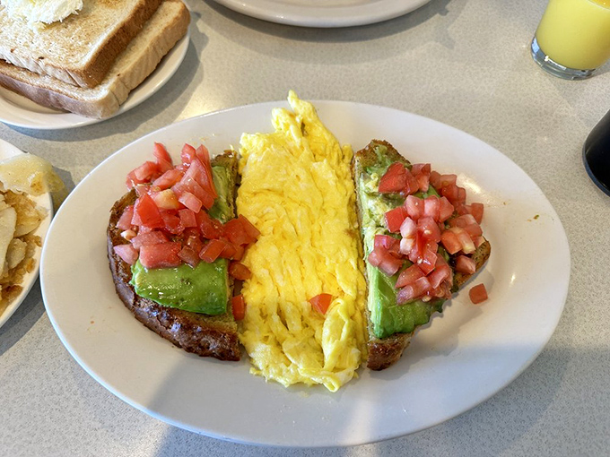 Breakfast architecture at its finest: creamy avocado slices flanking perfectly scrambled eggs, a California dream on Philadelphia toast. 
