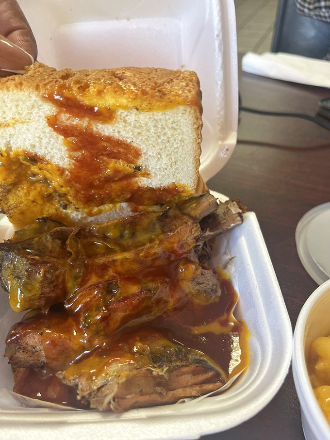 Sauce-slathered ribs that make you forget table manners exist. That white bread isn't decorative&mdash;it's there to soak up every last drop of barbecue magic.