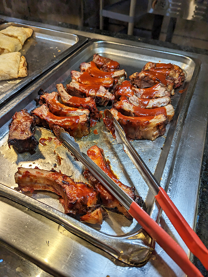 BBQ ribs glistening with sauce, waiting for their moment of glory on your plate. Napkins are not optional here, folks.