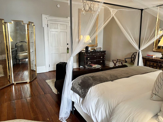 Drift off to dreamland beneath diaphanous canopy curtains in this serene bedroom, where modern luxury meets 19th-century architectural details.