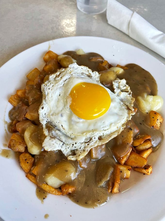Breakfast poutine that would make a Canadian weep with joy. That sunny-side egg crowns a kingdom of potatoes and gravy like edible royalty.