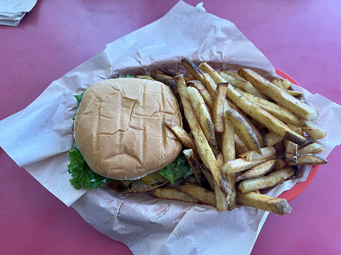 Simplicity perfected: a no-nonsense burger paired with hand-cut fries on butcher paper. The kind of meal that makes you question why we ever complicated food.