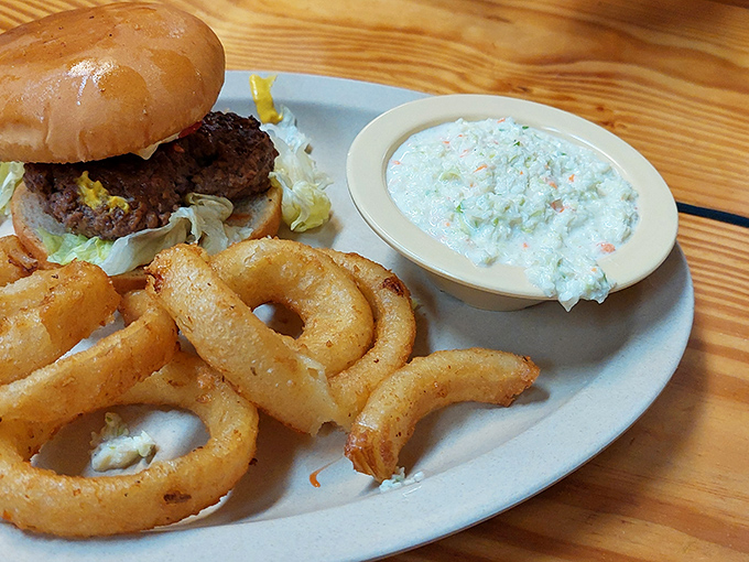 That perfect trio&mdash;juicy burger, crispy onion rings, and creamy coleslaw&mdash;a holy trinity of comfort that makes Monday feel like Saturday.
