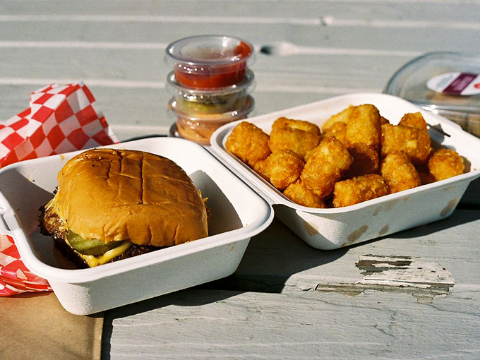 Heaven comes in two containers: a perfect burger alongside golden tater tots that crunch loud enough to drown out your "food happiness" noises.