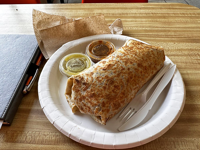 Not all heroes wear capes, some come wrapped in tortillas. This perfectly grilled burrito, flanked by salsa soldiers, is ready for its moment of glory.