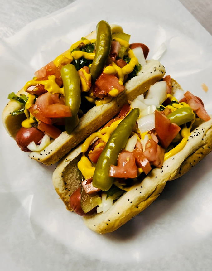These Chicago-style hot dogs aren't just topped &ndash; they're carefully architected with fresh tomatoes, onions, and those essential green sport peppers that say "I mean business."