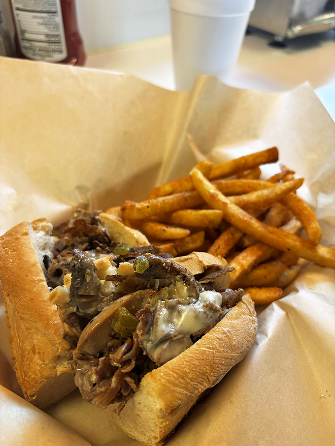 Behold the star of our show&mdash;thinly sliced beef cozying up with melted cheese on a perfect roll, with crispy fries playing the essential supporting role.