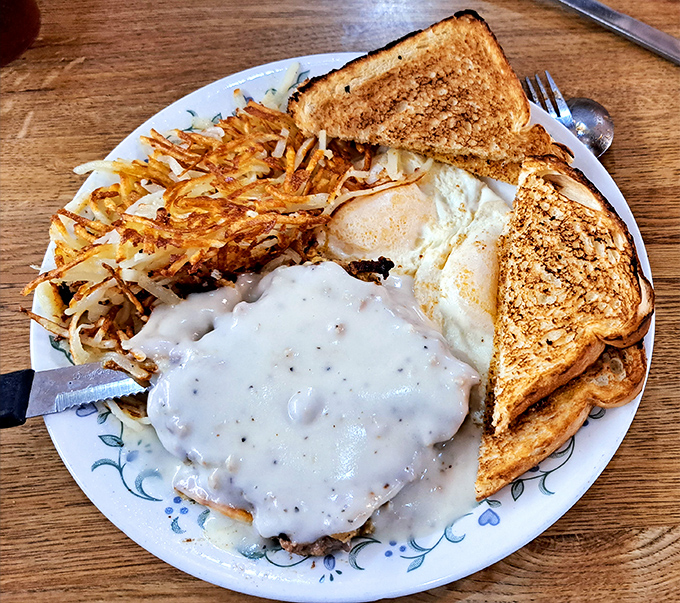 Gravy so peppery and rich it should have its own ZIP code, smothering a chicken fried steak that refuses to be contained by the plate.