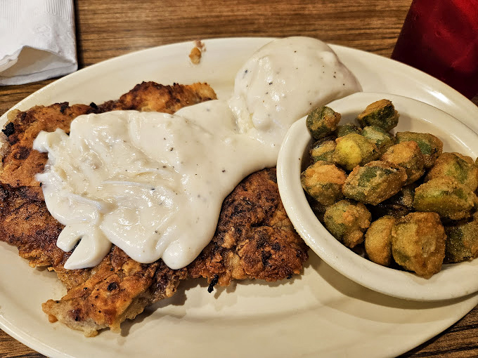 Golden-crusted chicken-fried steak shares the plate with crispy okra and a loaded baked potato – the holy trinity of Oklahoma comfort food.