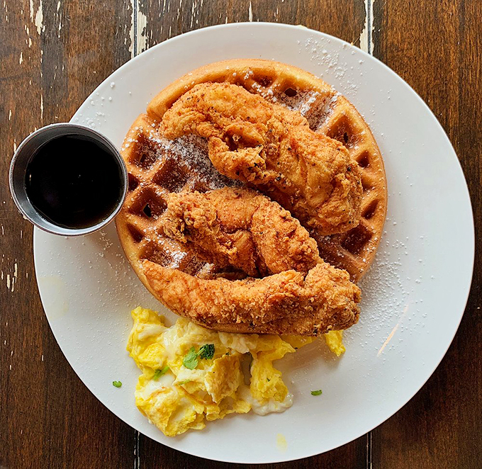 Golden-fried chicken perched atop a waffle throne with syrup standing by. The breakfast equivalent of having both cake and eating it too.