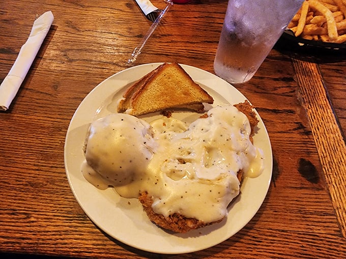 Behold the crown jewel: chicken fried steak swimming in creamy gravy alongside those legendary mashed potatoes. This plate doesn't just feed you – it hugs you from the inside.