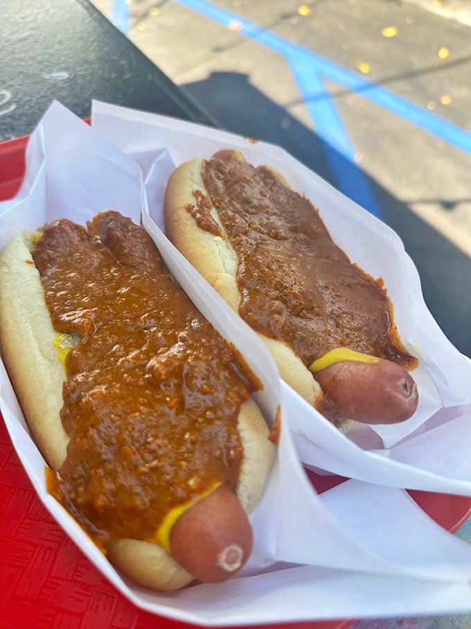Two perfect specimens of hot dog artistry. The chili clings lovingly to each dog like it was destined for this moment of culinary matrimony.