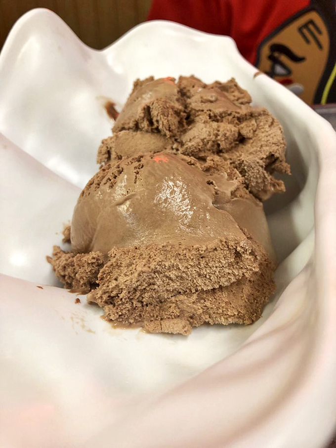 Chocolate ice cream so rich it should file its own tax return, nestled in that signature seashell dish like a cocoa-flavored treasure.