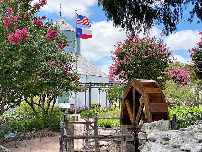 A peaceful garden oasis where crape myrtles frame a white chapel, offering a quiet respite from Main Street's cheerful bustle.