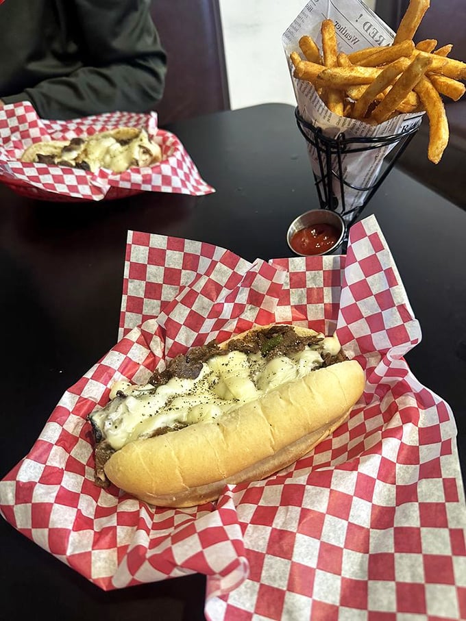 The holy trinity of comfort food: a perfectly melted cheesesteak, golden fries, and the anticipation of that first magnificent bite.