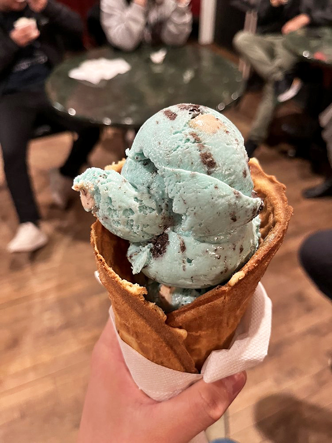 Cookie Monster would approve this blue masterpiece. The waffle cone's malted perfection cradles chunks of cookie in a sea of azure bliss.