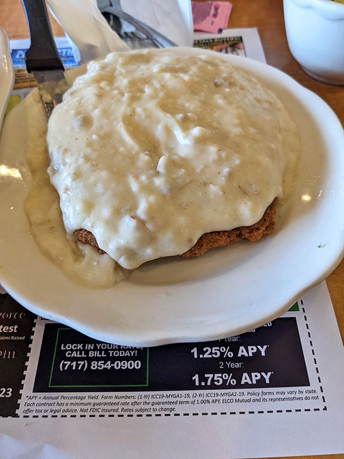 Country fried steak smothered in creamy gravy &ndash; a dish so good it might make you forget your table manners. 