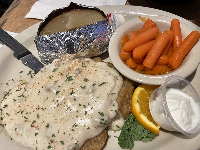Country fried steak smothered in peppery cream gravy &ndash; where crispy exterior meets tender meat in a dance that would make Fred Astaire jealous.