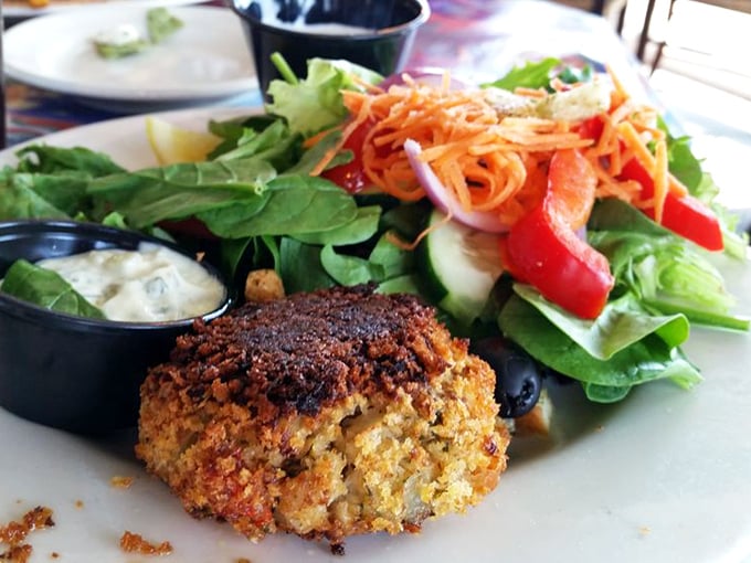 The star of the show in its natural habitat: a perfectly golden crab cake that's more crab than cake, served with a salad that knows its supporting role.