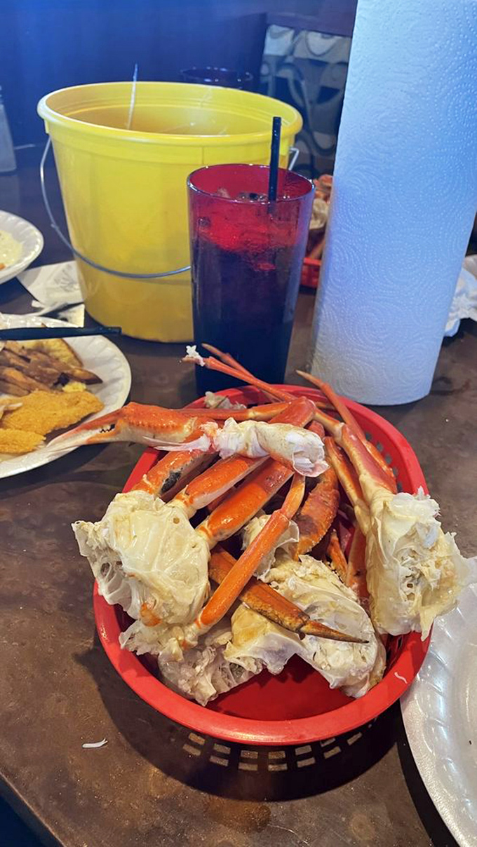 Snow crab legs arranged like nature's perfect puzzle. The yellow bucket isn't decoration&mdash;it's your new best friend for discarded shells.