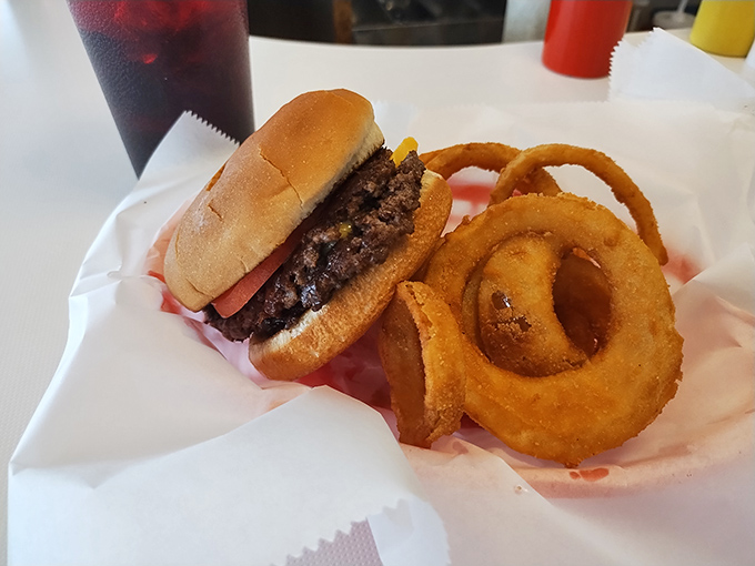This isn't just a burger and onion rings &ndash; it's edible poetry on wax paper, where beef meets bun in a relationship that was clearly meant to be.