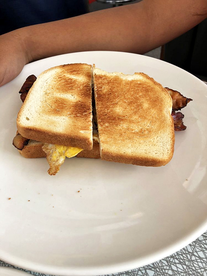 Breakfast sandwich perfection doesn't require fancy ingredients&mdash;just proper execution. That golden toast and peeking bacon is the morning equivalent of a perfect sunset.