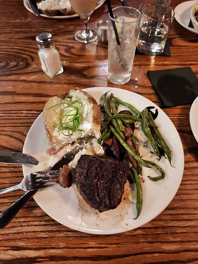 Your plate is waiting with a perfectly seared steak, a fluffy loaded potato, and fresh green beans for your dinner.