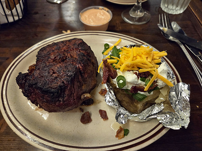 This isn't just a steak; it's a monument to simplicity done right. The char speaks of open flame, while that loaded potato whispers, "Save room for me too."