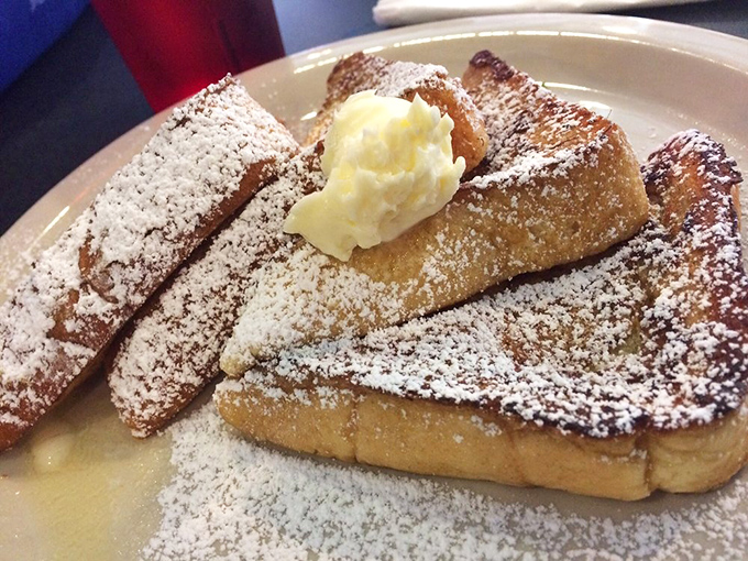 Golden-brown French toast dusted with powdered sugar and topped with a melting pat of butter. Breakfast architecture at its most magnificent.