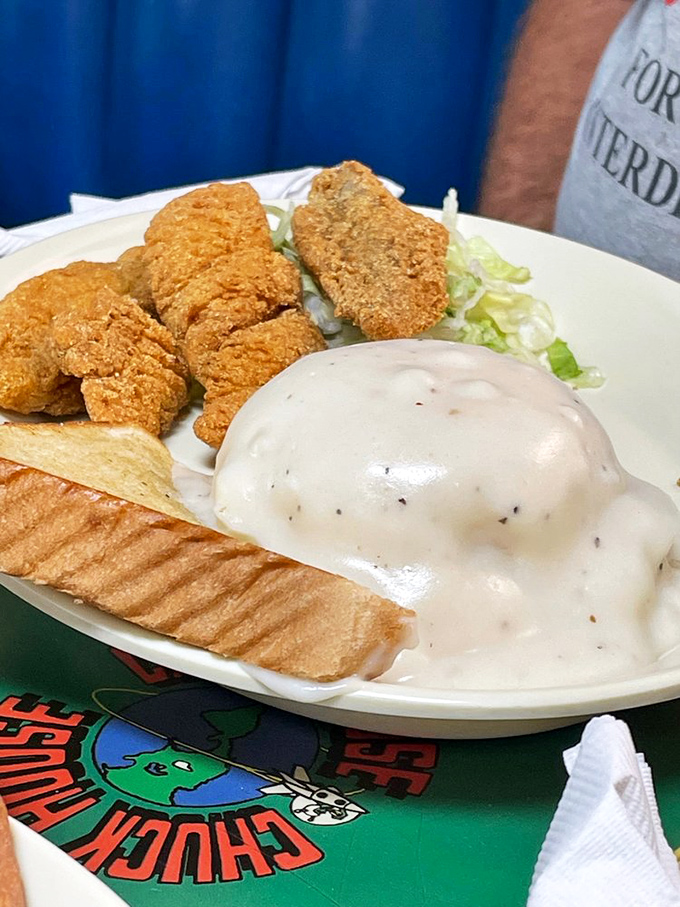 Golden-battered catfish that looks like it's trying to escape the plate. The white gravy isn't just a topping&mdash;it's a warm, peppery blanket.