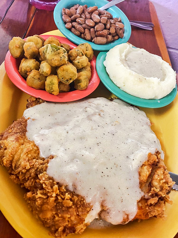 Behold the star of the show: golden-fried chicken under a blanket of peppery gravy, with sides that refuse to be mere supporting actors.
