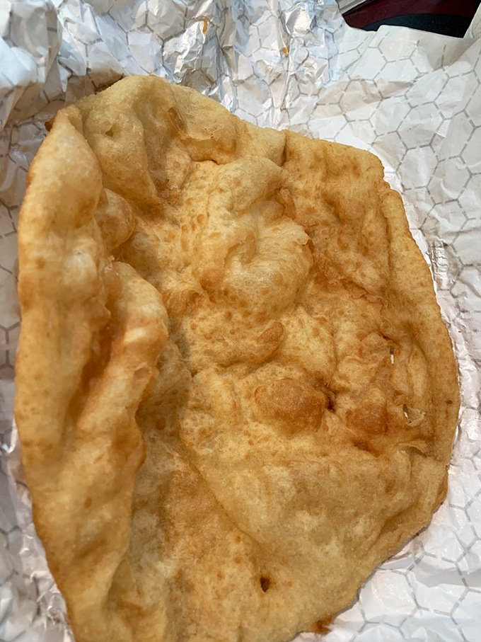 Golden, puffy perfection on aluminum foil. This pillowy disc of fried dough is the canvas upon which culinary magic happens.