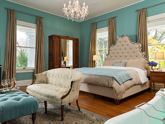 Tiffany blue walls cradle a bedroom fit for Southern royalty. That chandelier has probably witnessed more romantic weekends than a Valentine's Day chocolate salesman.