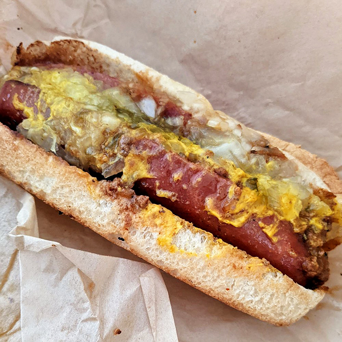 The half-smoke in all its glory: a smoky sausage nestled in a soft bun, smothered with chili and mustard&mdash;a DC area tradition since Eisenhower was president.