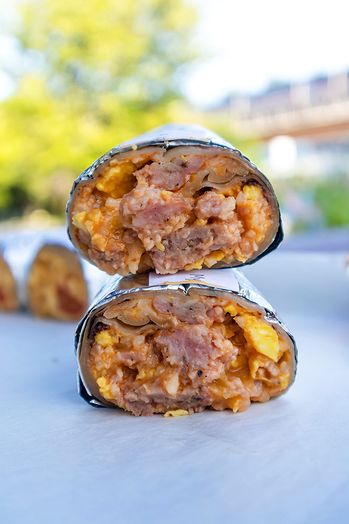 Behold the cross-section of breakfast perfection. This burrito's interior architecture reveals the golden marriage of eggs, potatoes, and meat that inspires morning pilgrimages.