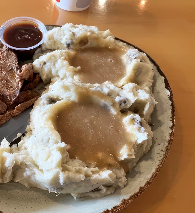 Behold, the mashed potato mothership! Creamy clouds with gravy lakes that make you question why you've wasted time on inferior spuds.