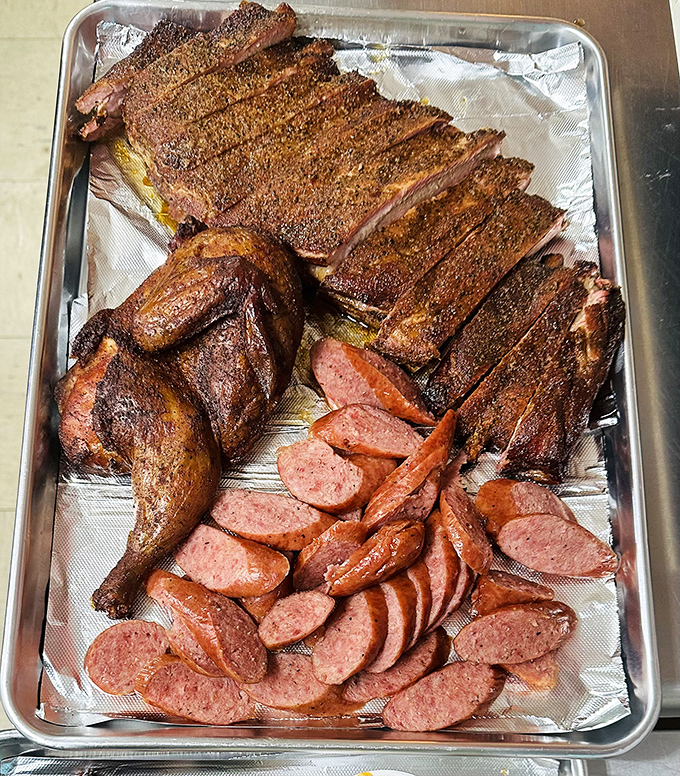 Meat candy in its natural habitat. This tray of ribs, chicken, and sausage isn't just food&mdash;it's edible evidence that patience is indeed a virtue.