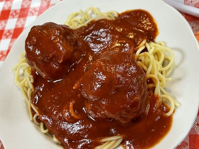 These meatballs don't just sit on the spaghetti—they command it, like tiny generals atop a mountain of perfectly cooked pasta battleground.